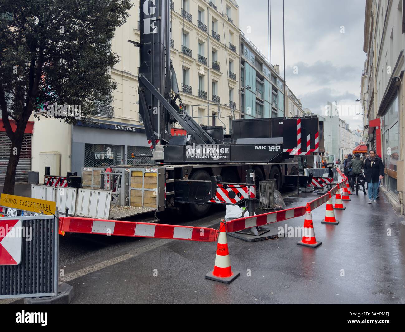 Crane operation on a bustling street in Paris showcases urban ...