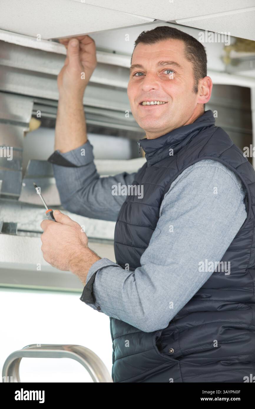 young man fixing drywall suspended ceiling Stock Photo - Alamy
