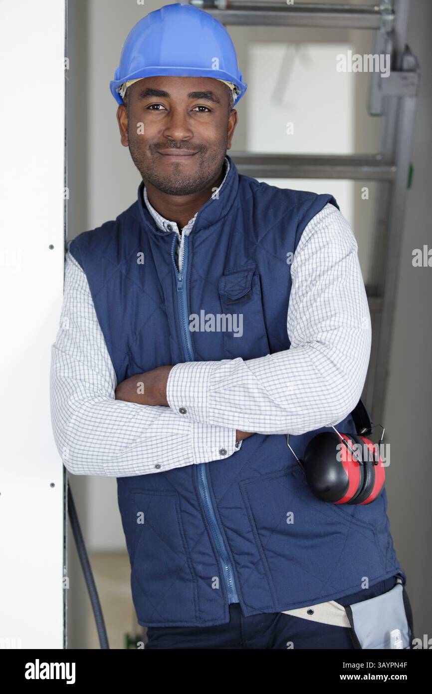 male tradesman leaning against a wall Stock Photo - Alamy