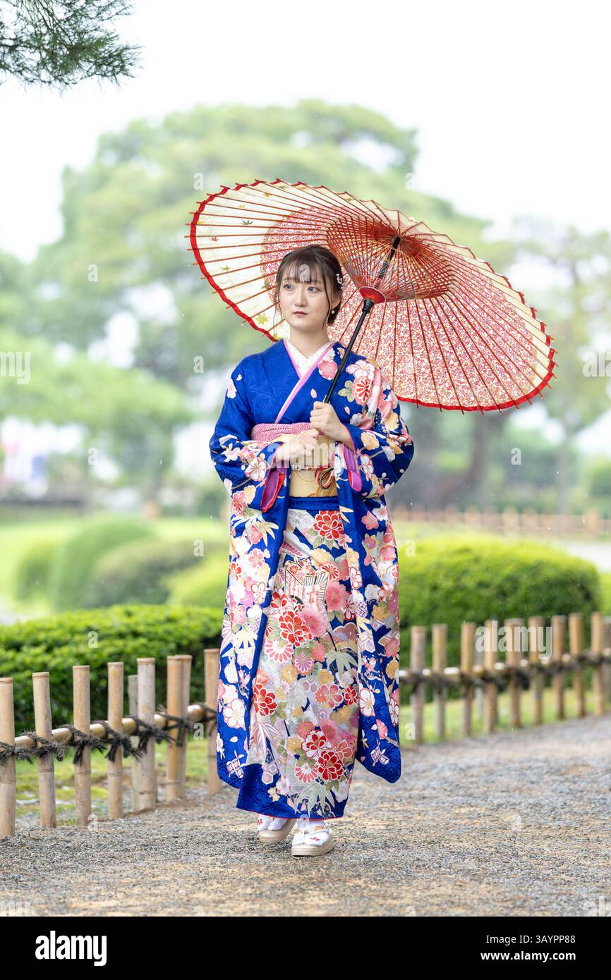 A local city in Japan on a rainy summer day. Japanese woman wearing a ...