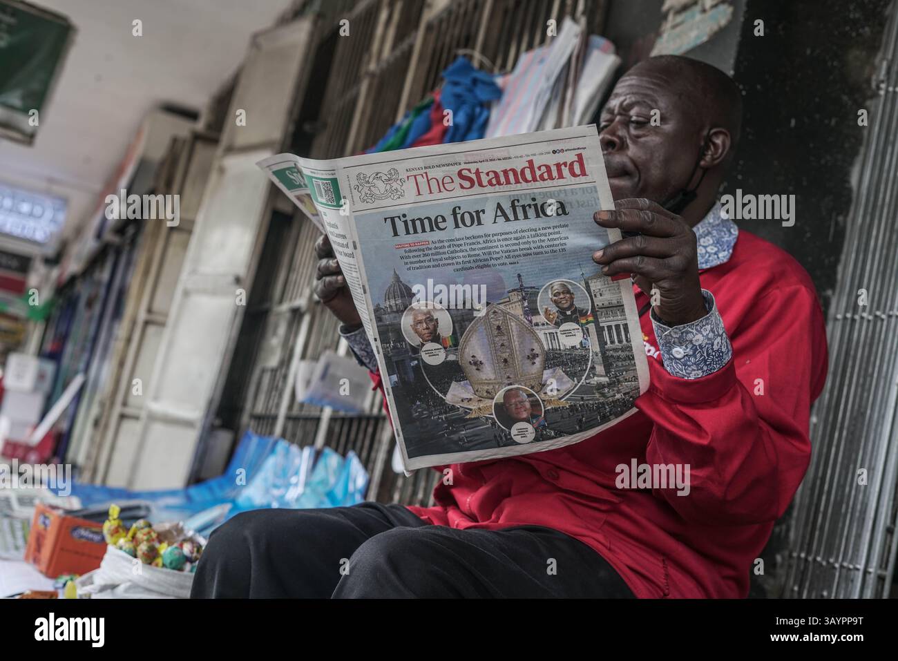 Nakuru, Kenya. 23rd Apr, 2025. A vendor reads a Kenyan newspaper, The ...