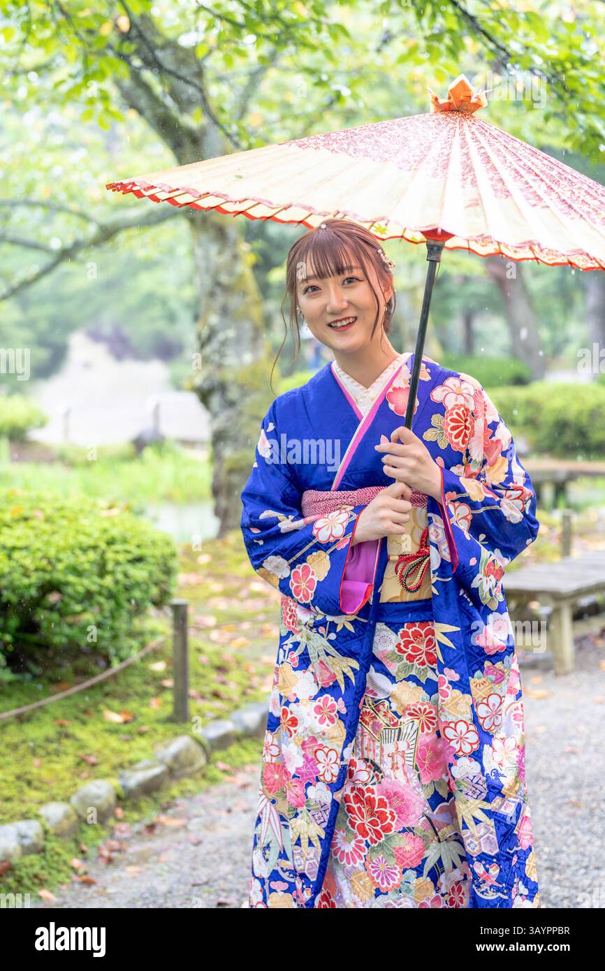 A local city in Japan on a rainy summer day. Japanese woman wearing a ...