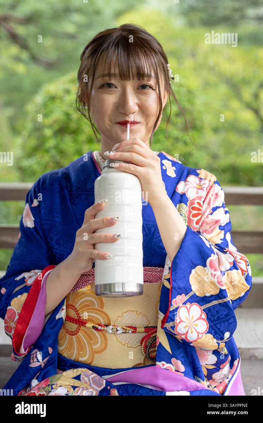 A local city in Japan on a rainy summer day. Japanese woman wearing a ...