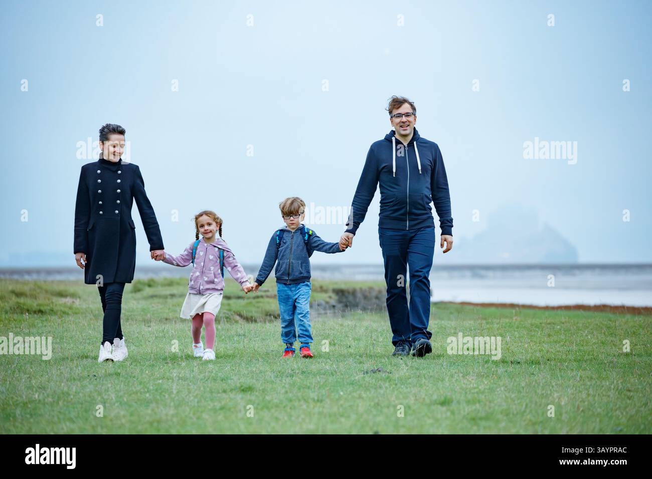 Parents and kids share fun outdoor stroll together in France Stock ...