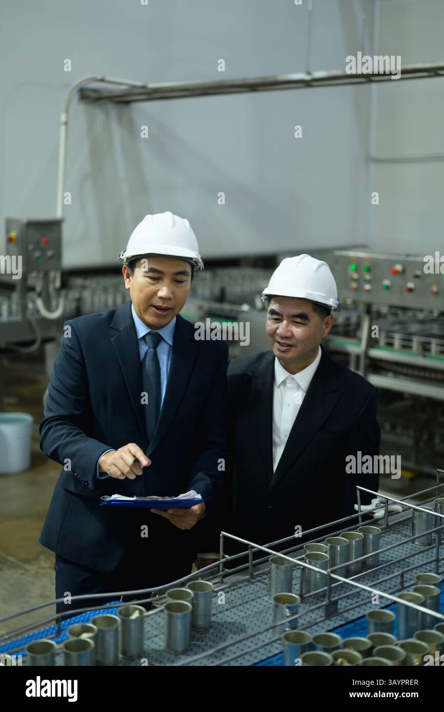 Two business professionals reviewing operations in a food production ...