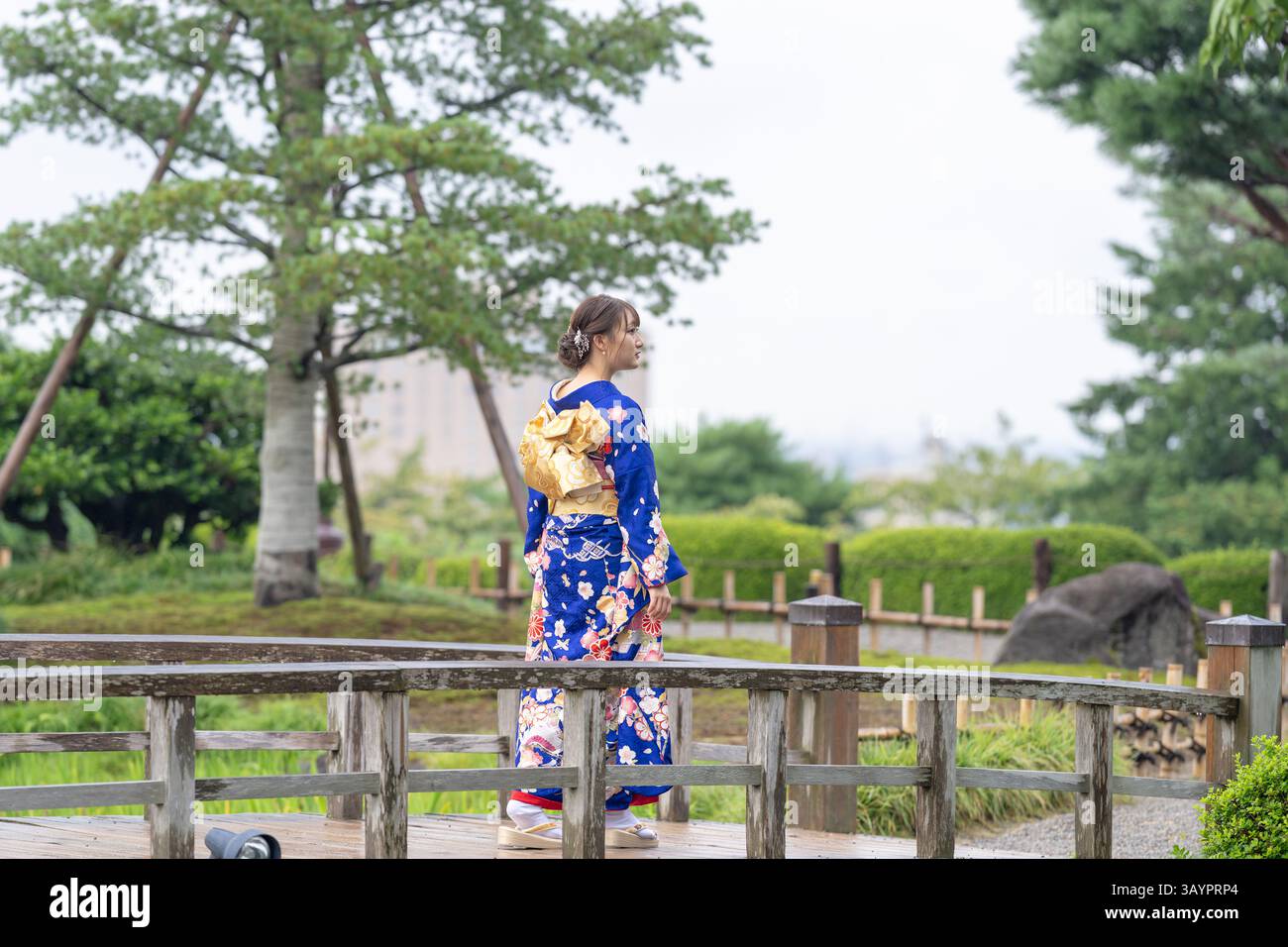 A local city in Japan on a rainy summer day. Japanese woman wearing a ...