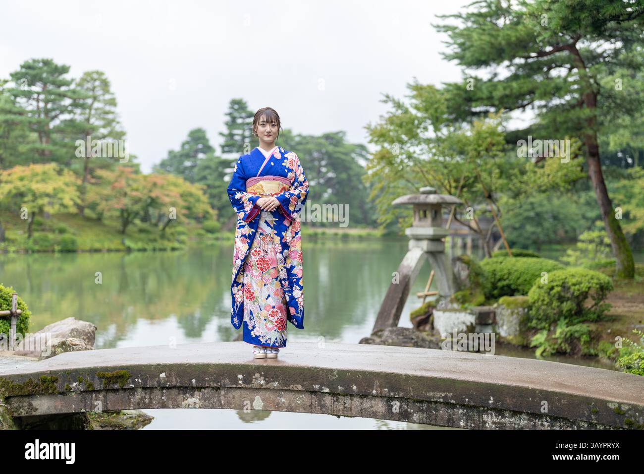 A local city in Japan on a rainy summer day. Japanese woman wearing a ...
