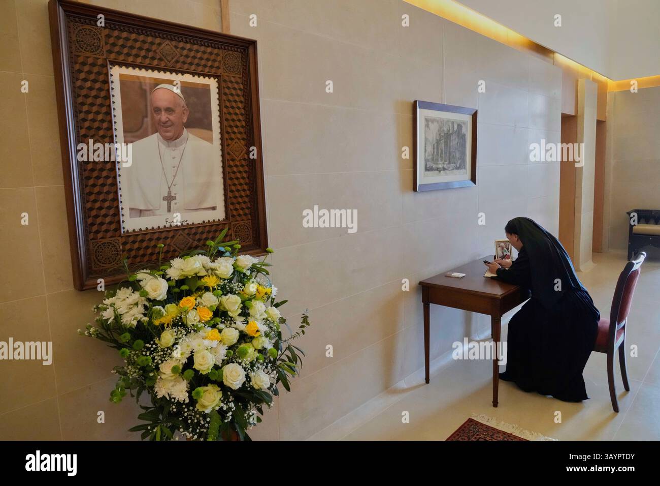 A nun signs a book of condolences on the passing of Pope Francis, at ...