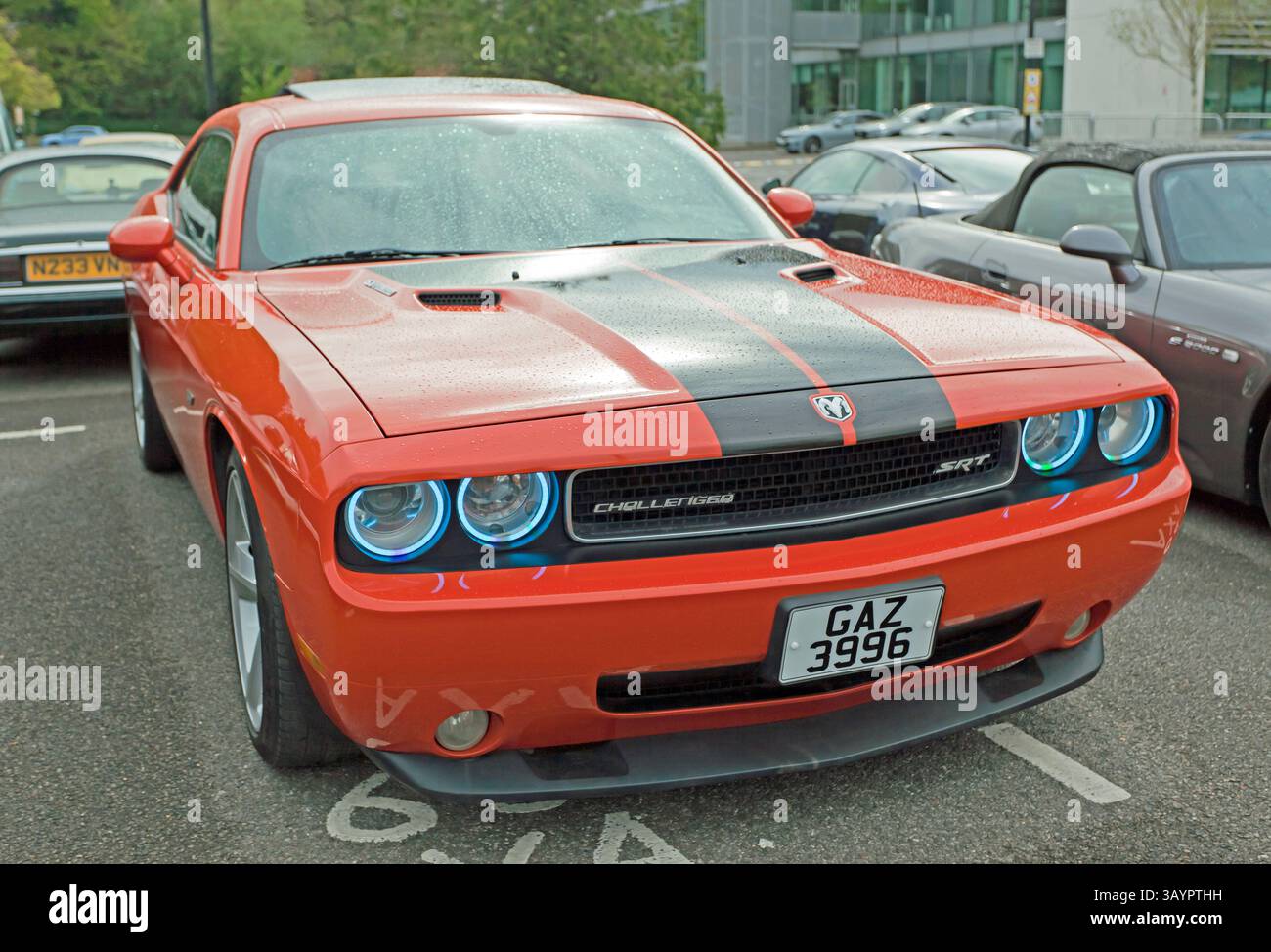 Three-quarters front view of an Orange, 2009, Dodge Challenger SRT, at ...
