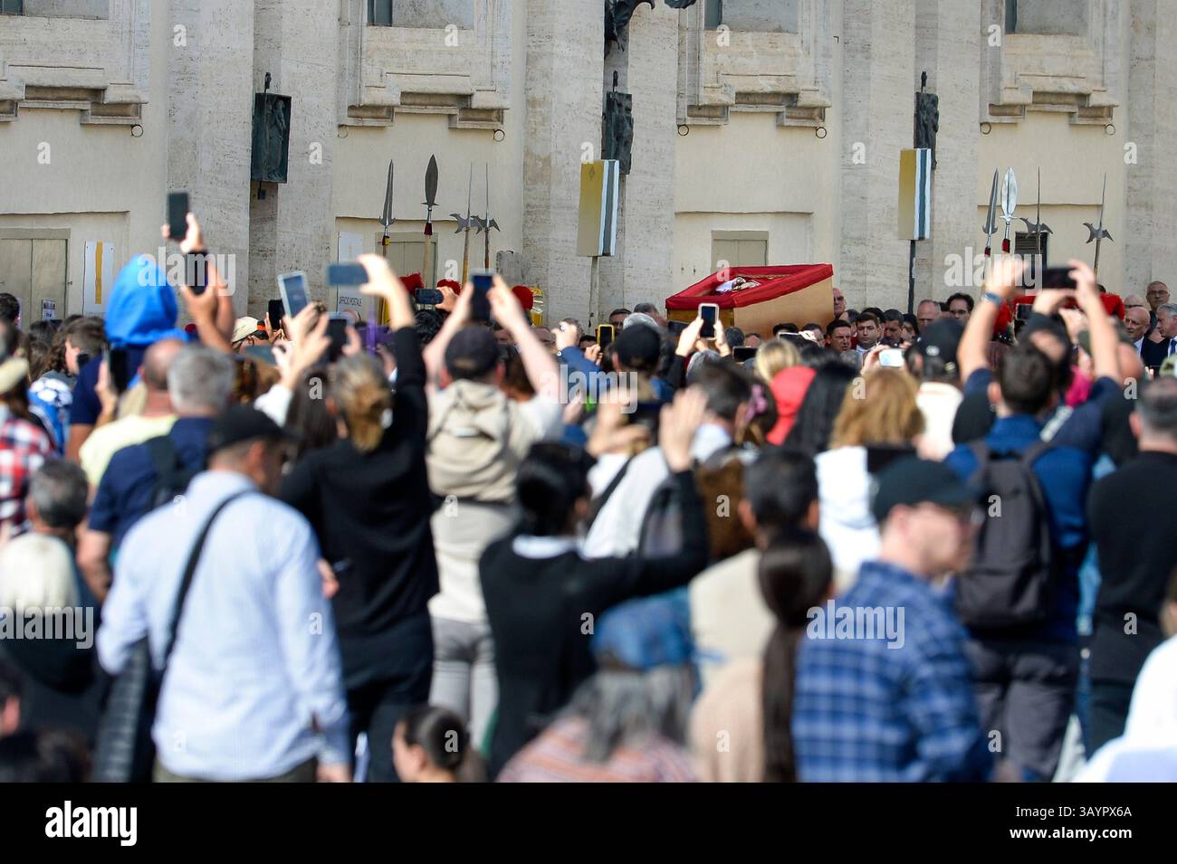 Hundreds of people watch the arrival of the coffin of Pope Francis I at St. Peter's Basilica ...