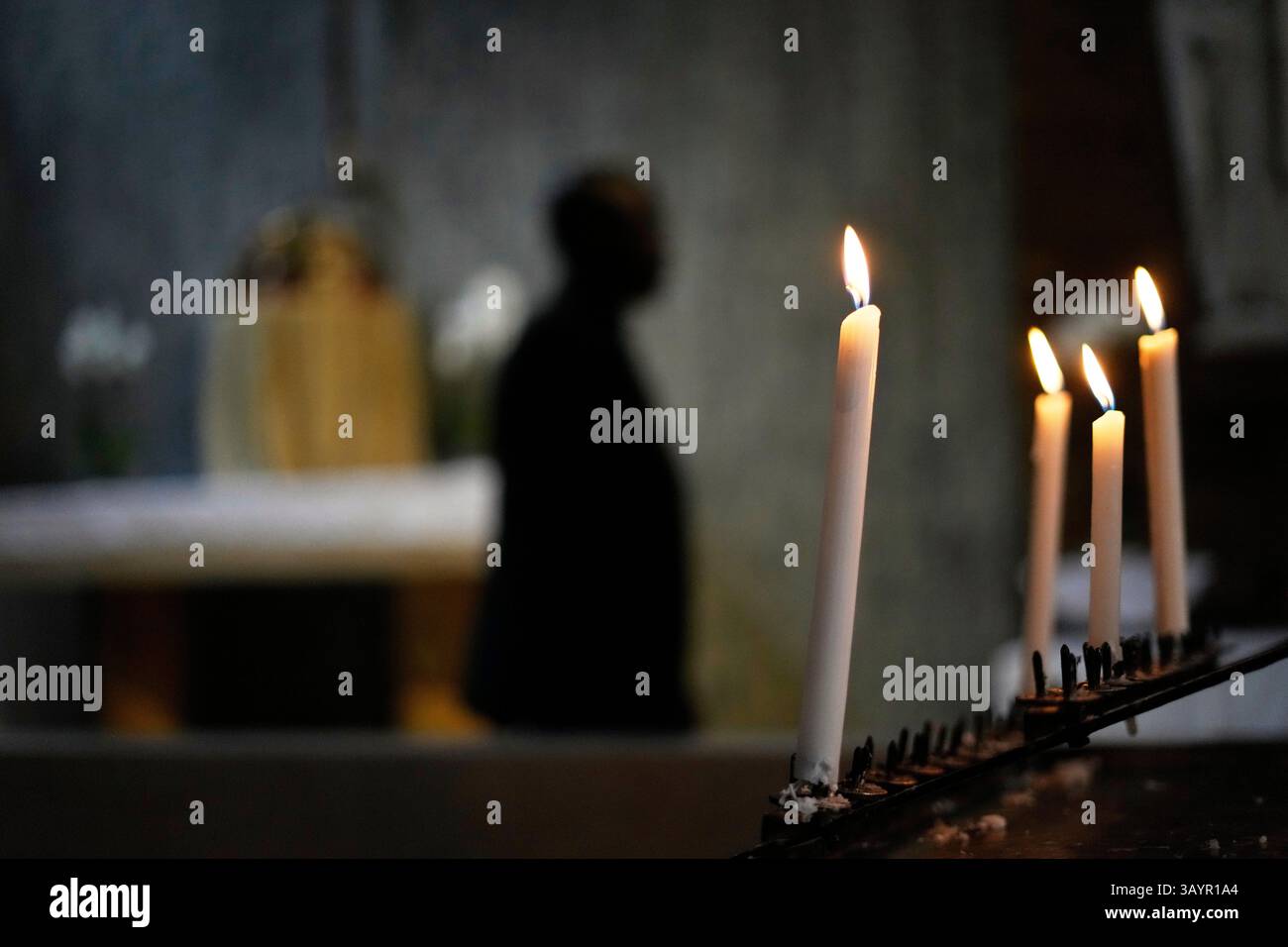 A man walks past prayer candles following Pope Francis Memorial Mass ...