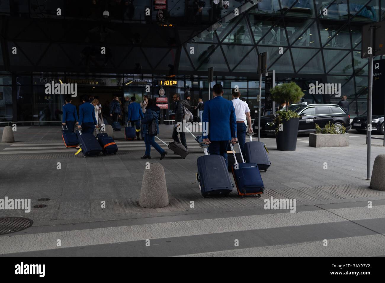 Flight attendants and pilots with trolley luggage bags walking in ...