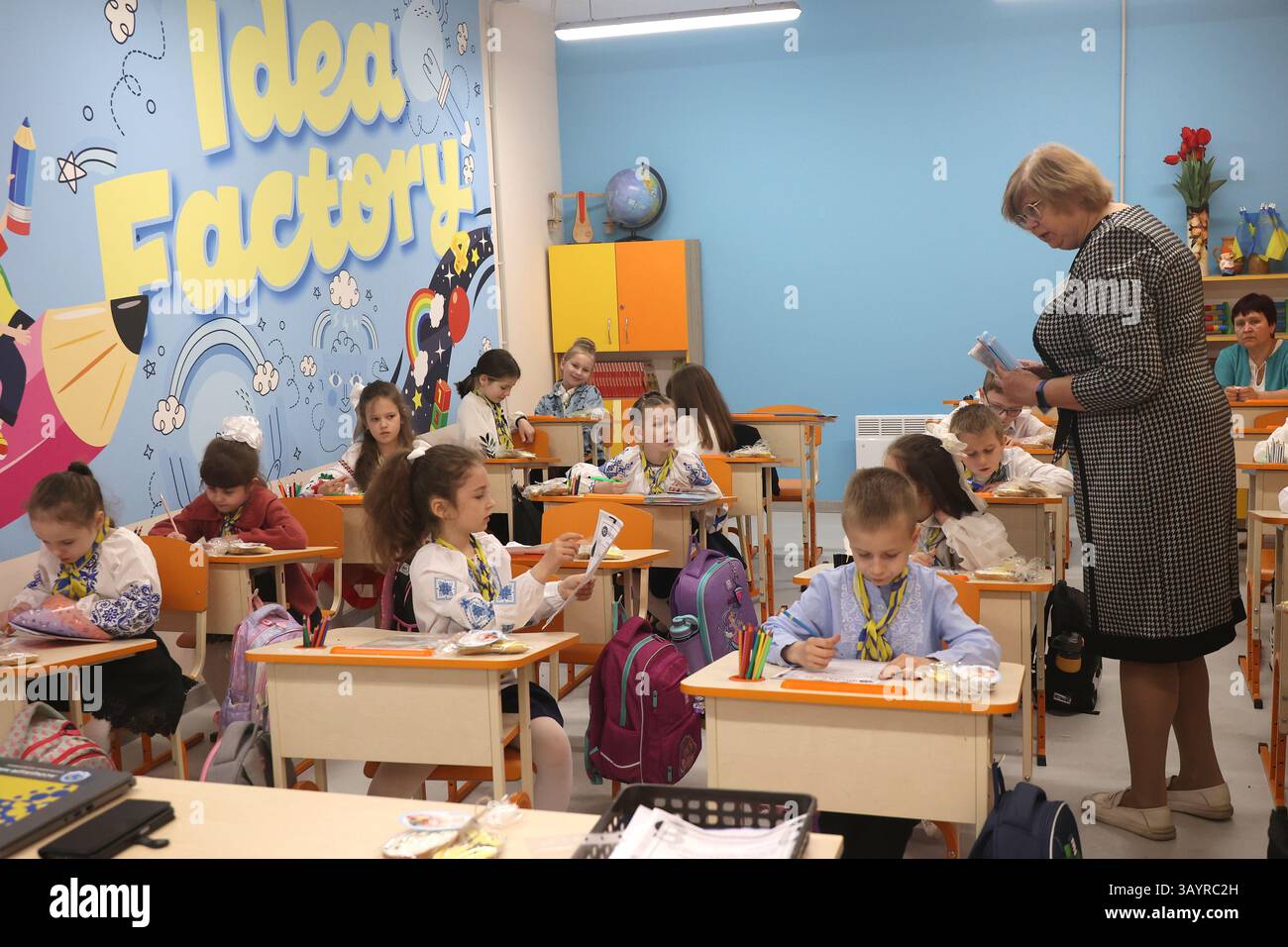 A teacher and students are seen in a classroom of a new underground ...
