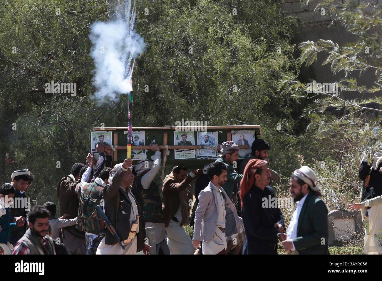 A Yemeni fires flares as people gather to burry victims of U.S ...