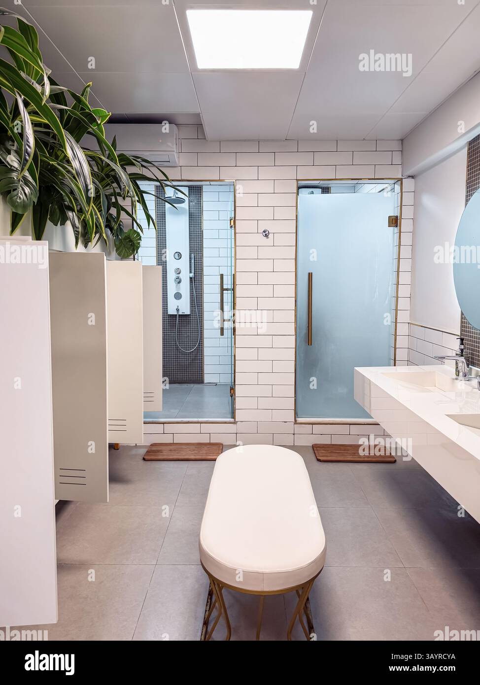 Stylish restroom features sleek glass partitions, minimalist vanity ...