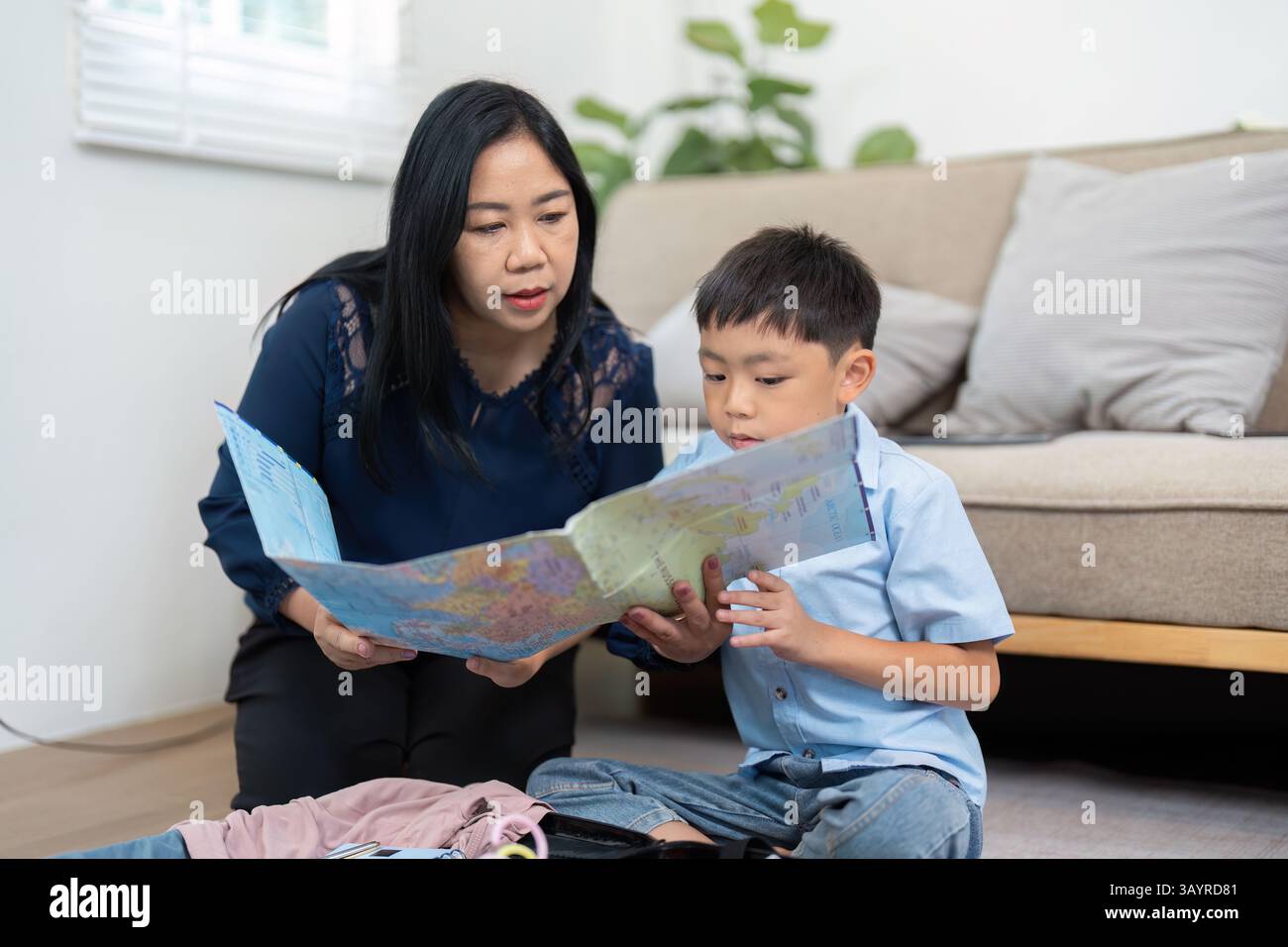 Exploration and Family Planning. A mother and son examine a map ...
