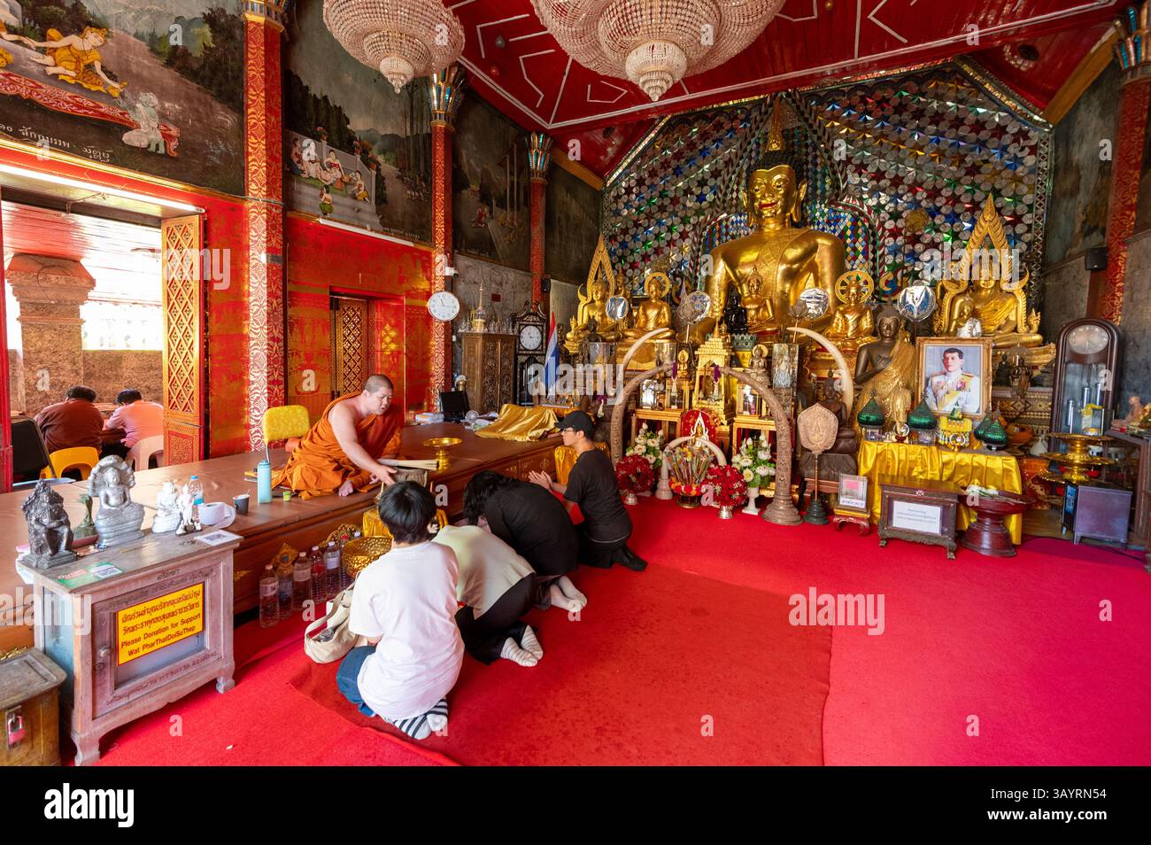 Interior of one of the prayer halls with a Buddhist monk who receives ...