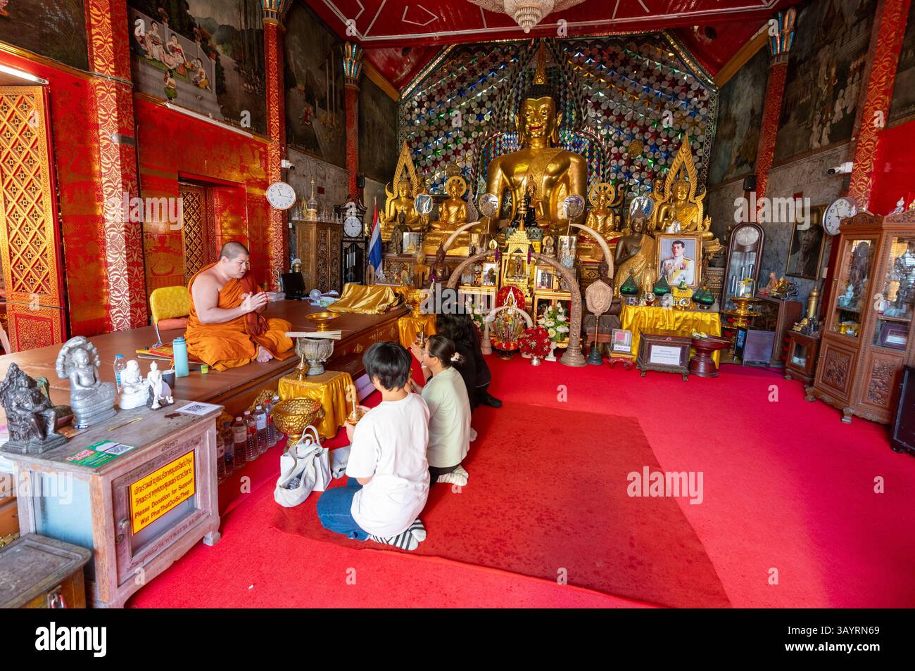 Interior of one of the prayer halls with a Buddhist monk who receives ...