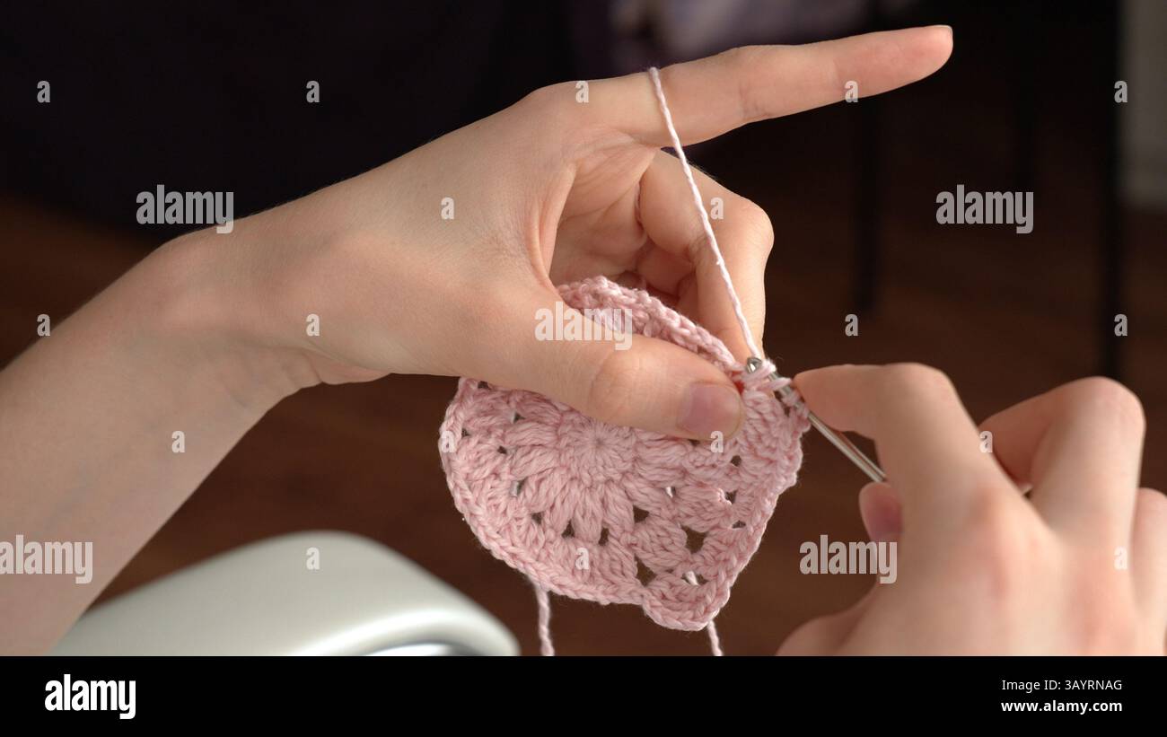 Hands expertly guide a crochet hook, creating delicate lace patterns ...