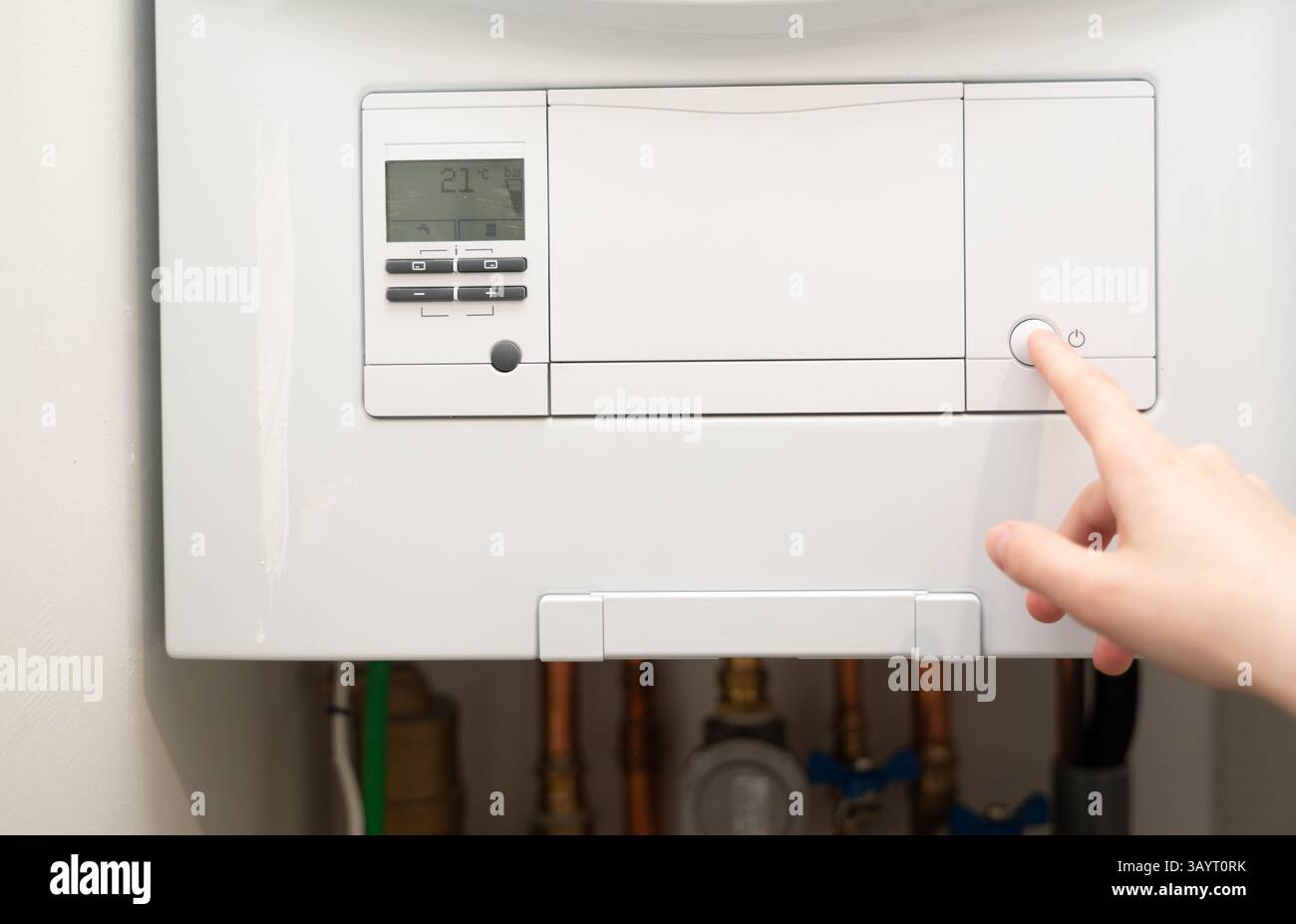 A hand skillfully adjusting a sleek and modern heating control panel in ...