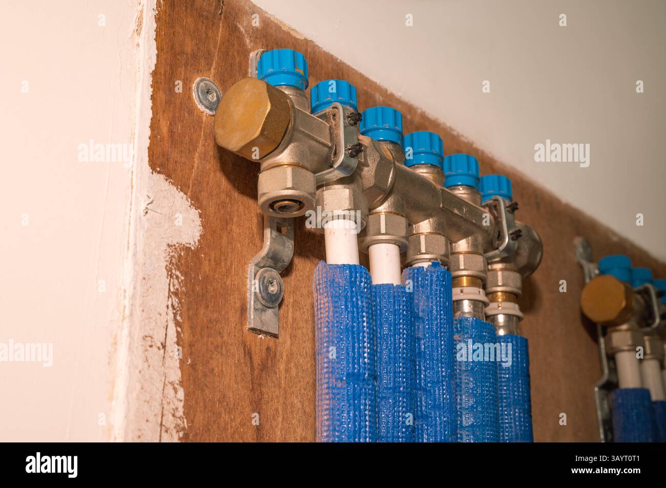 A close-up view of a plumbing system featuring PEX tubing and valves ...