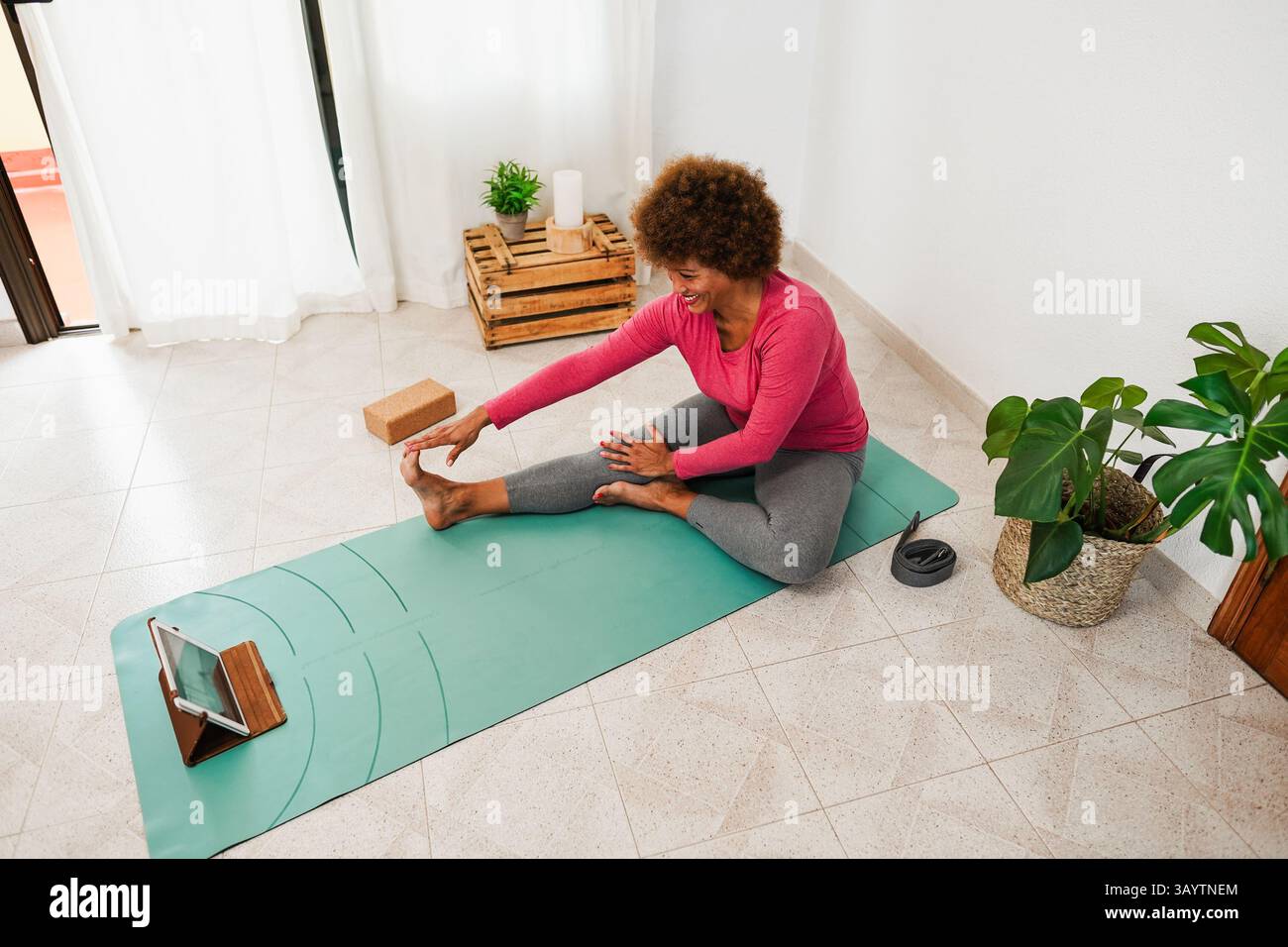 African american senior woman doing yoga online session at home ...