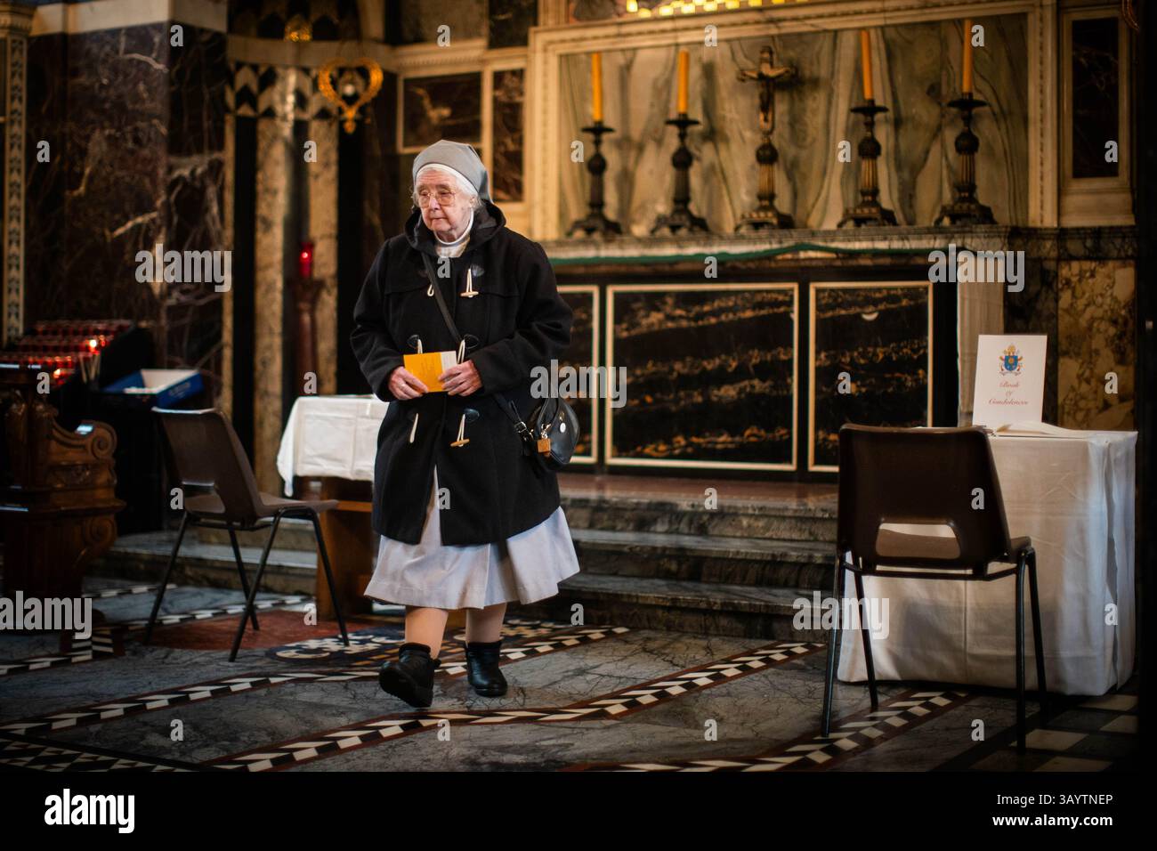 A nun signs a book of condolences for Pope Francis at Westminster ...