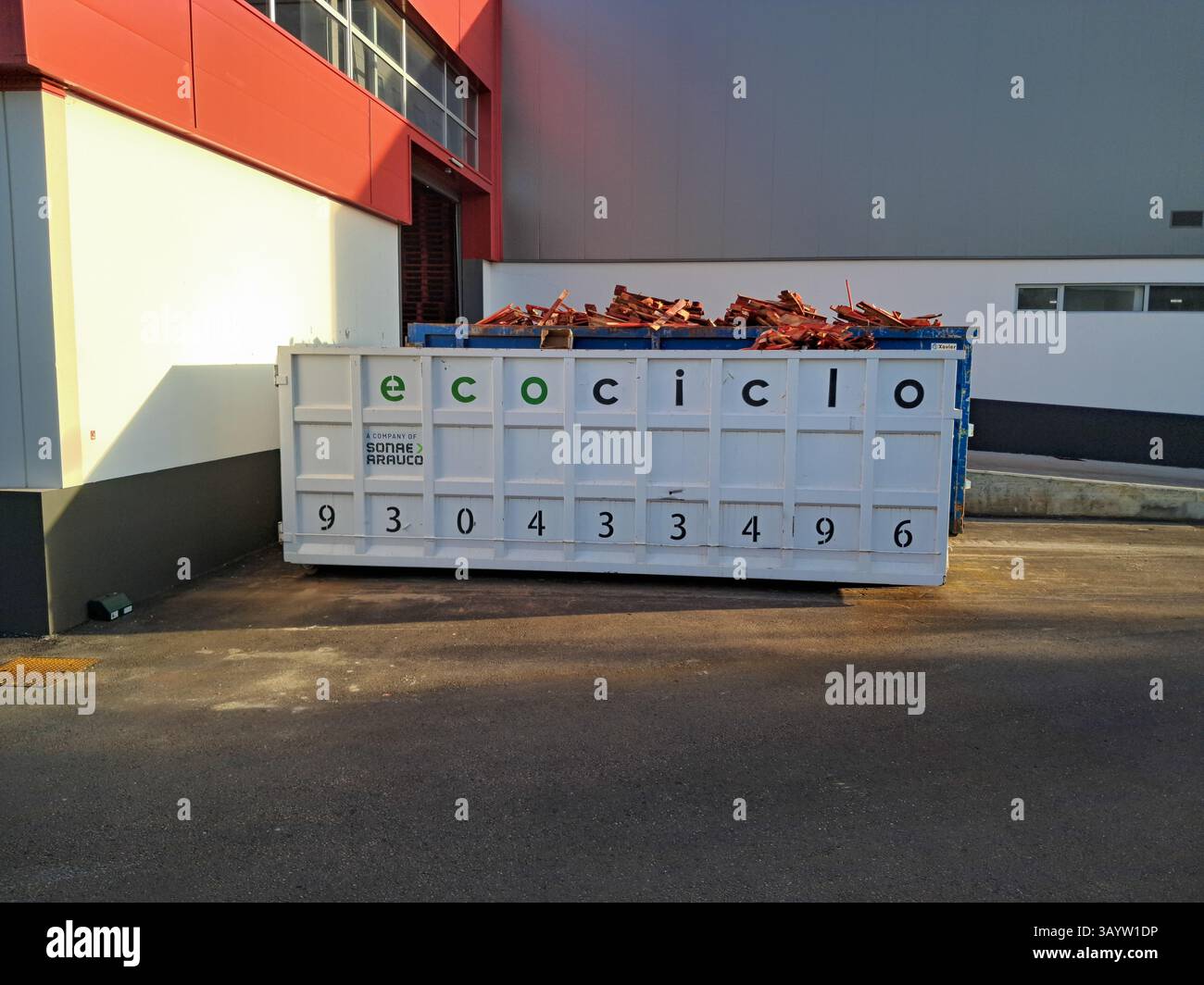 Industrial dumpster collecting wood waste for recycling, promoting ...