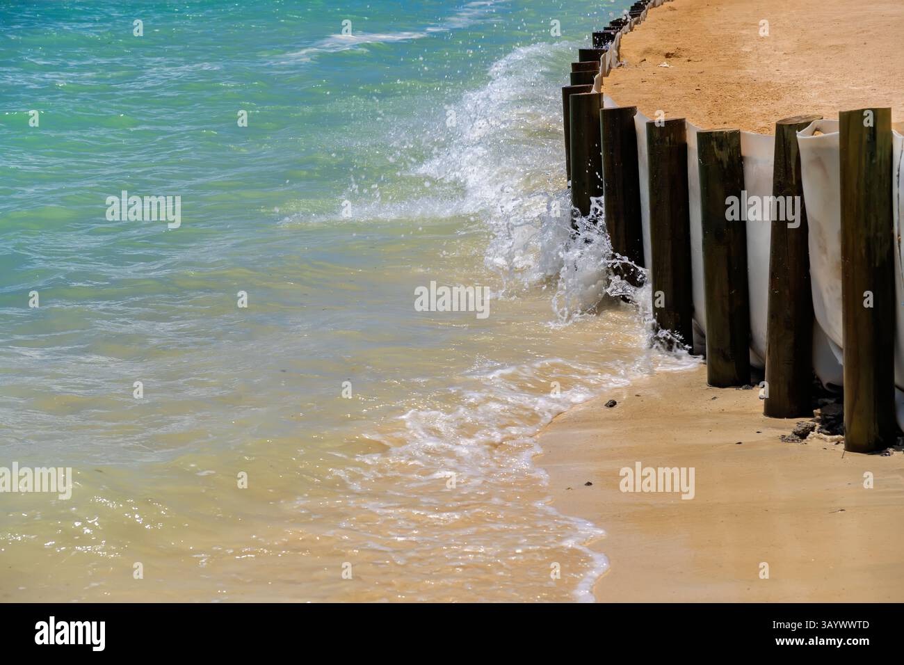 Wooden Groynes on Sandy Beach with Turquoise Waves Splashing Against ...
