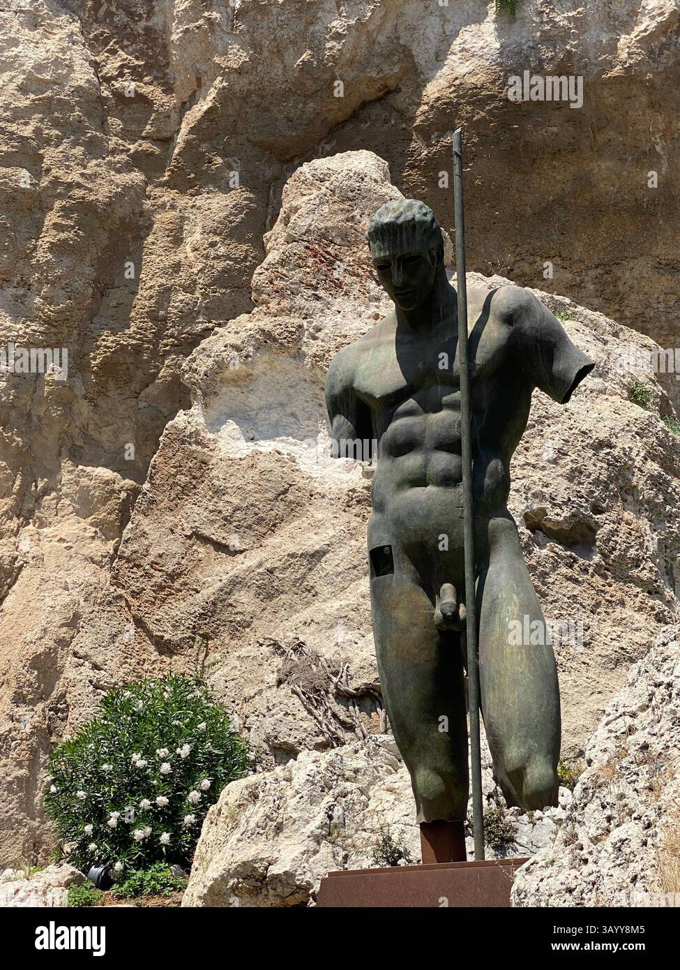 Bronze warrior statue gripping spear, standing amid ancient Latomie del ...
