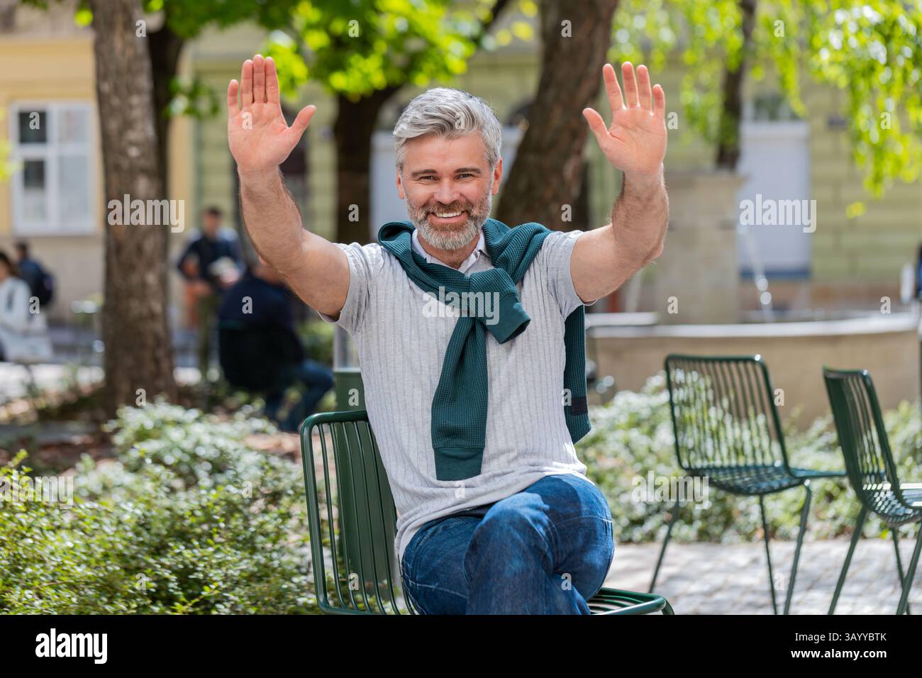 Cheerful mature man tourist smiling friendly at camera, waving hands ...