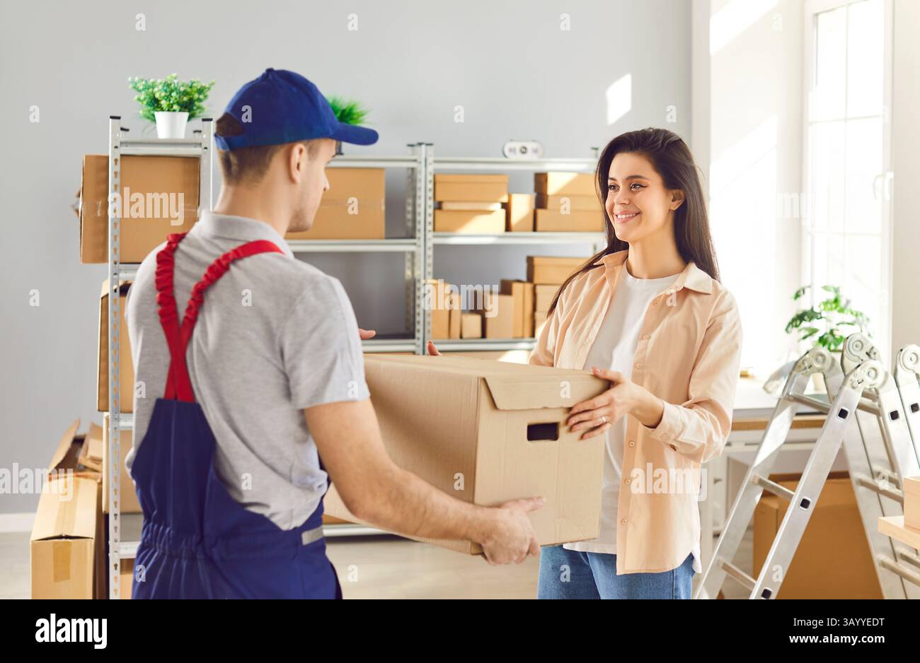 Man from delivery service working in warehouse with female small ...