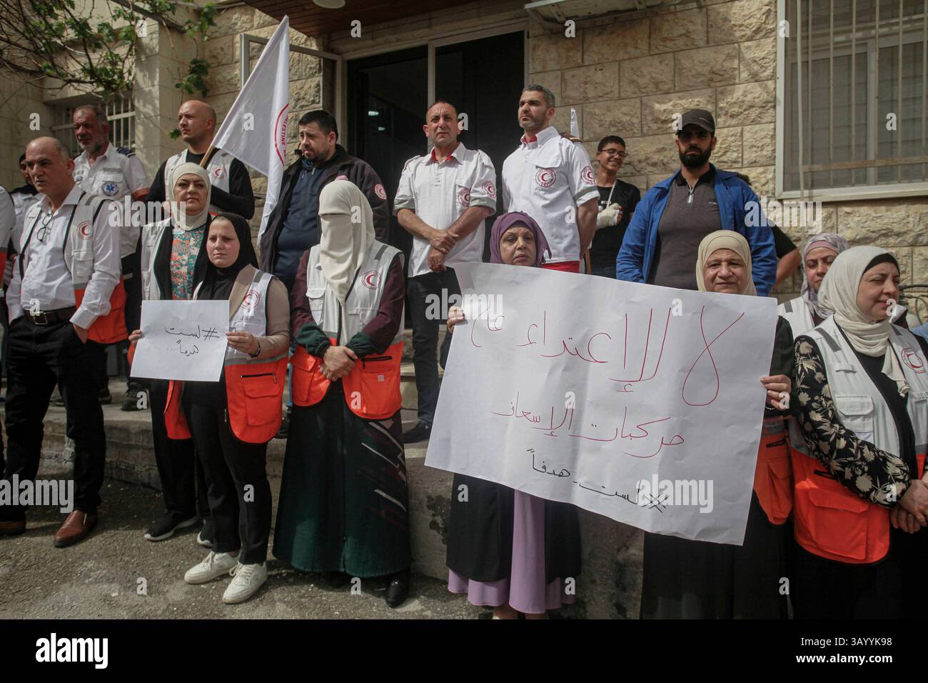 Palestinian Red Crescent Society paramedics hold banners in honor of ...
