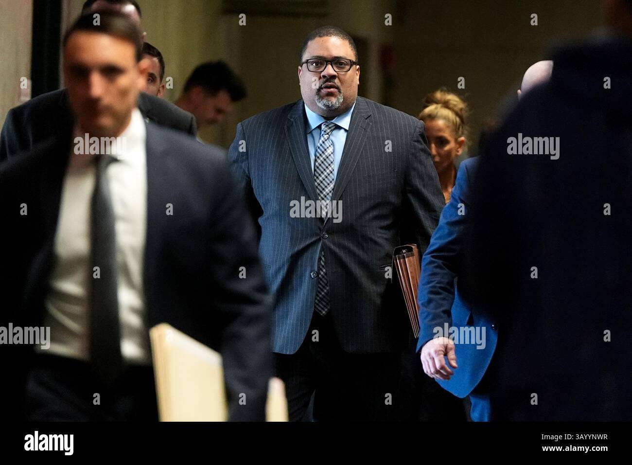 Manhattan district attorney Alvin Bragg, center, walks through ...