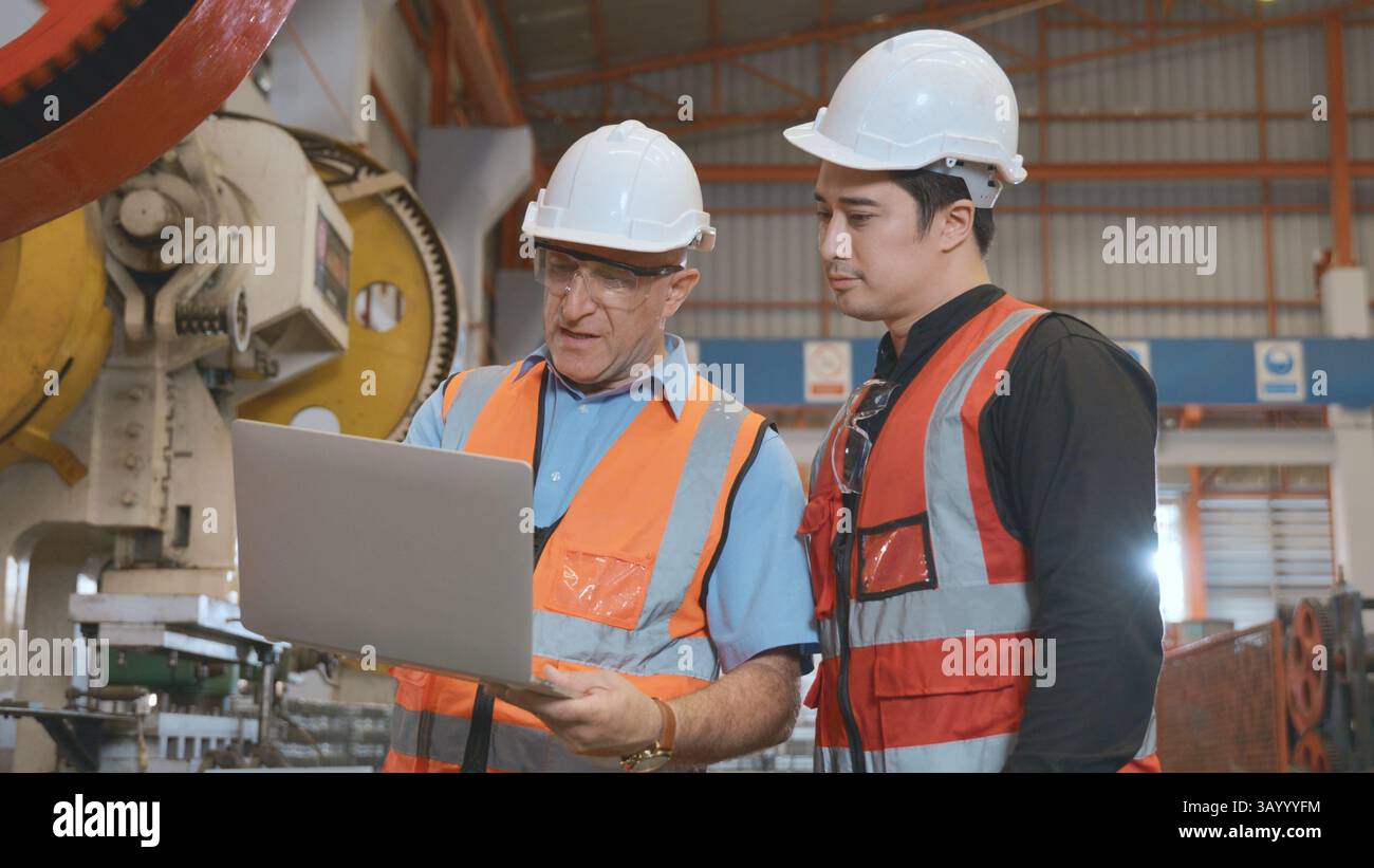 Engineer teaching apprentice to use metal sheet stamping machine Stock ...