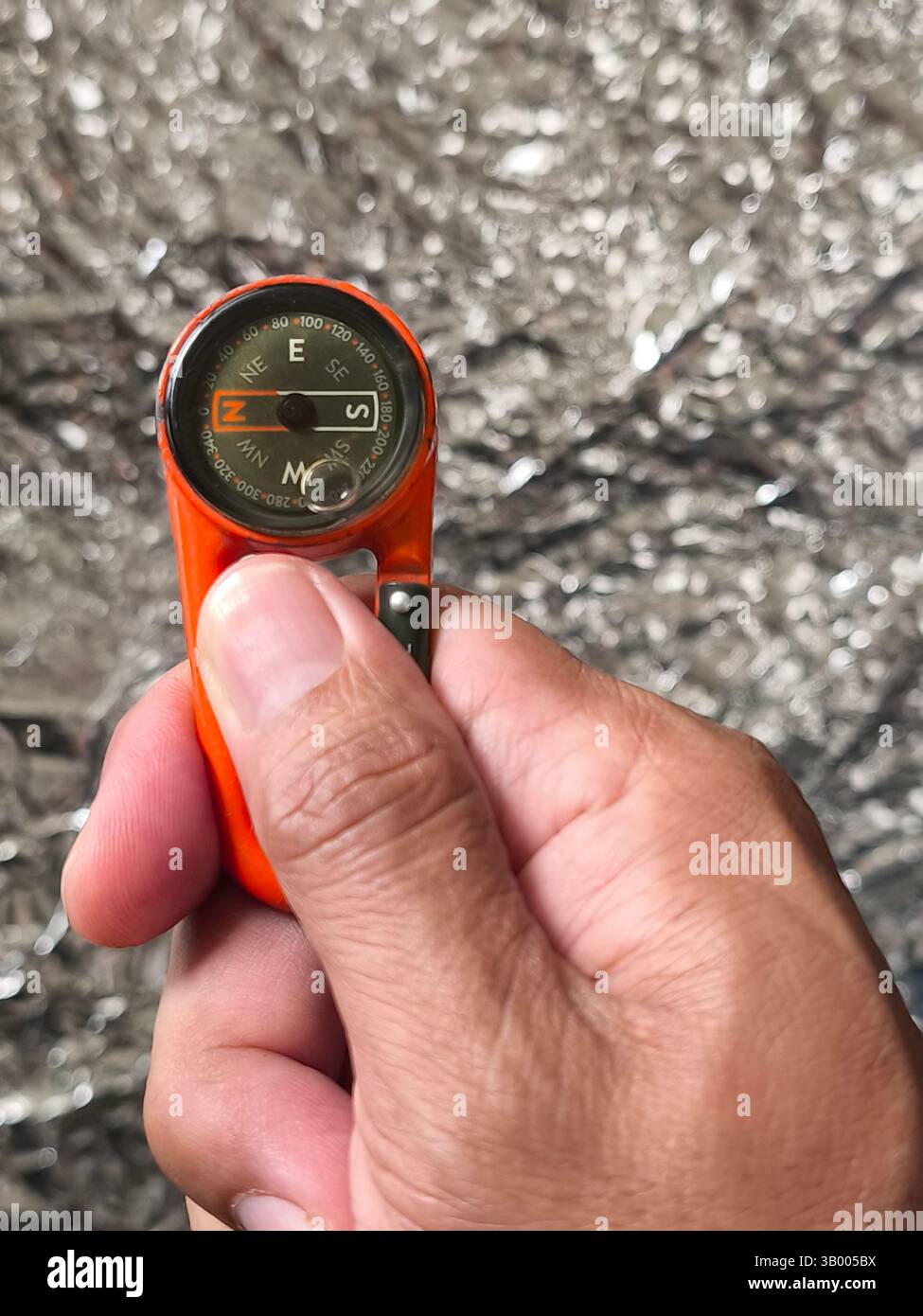 a hanging compass held in the right hand Stock Photo - Alamy