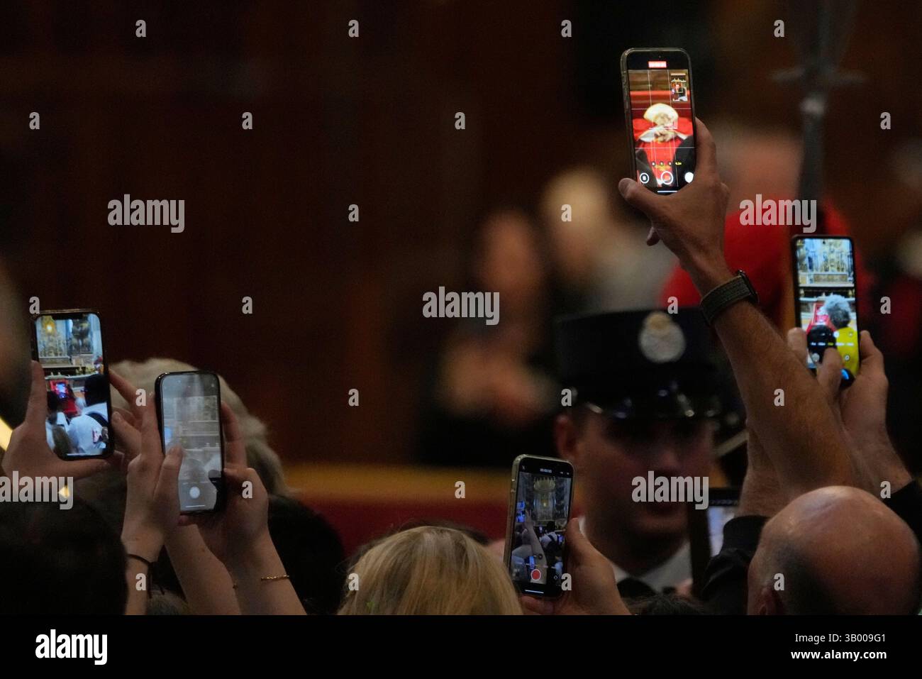 Faithful take pictures with their smartphones as they pay their ...