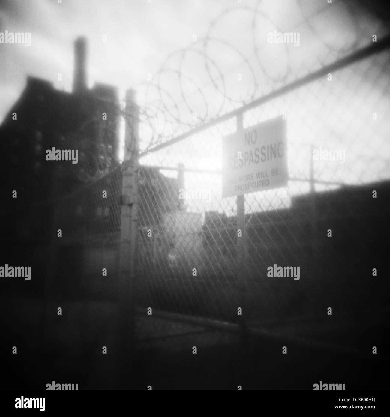 Old fashioned black and white image of a barbed wire fence in front of ...