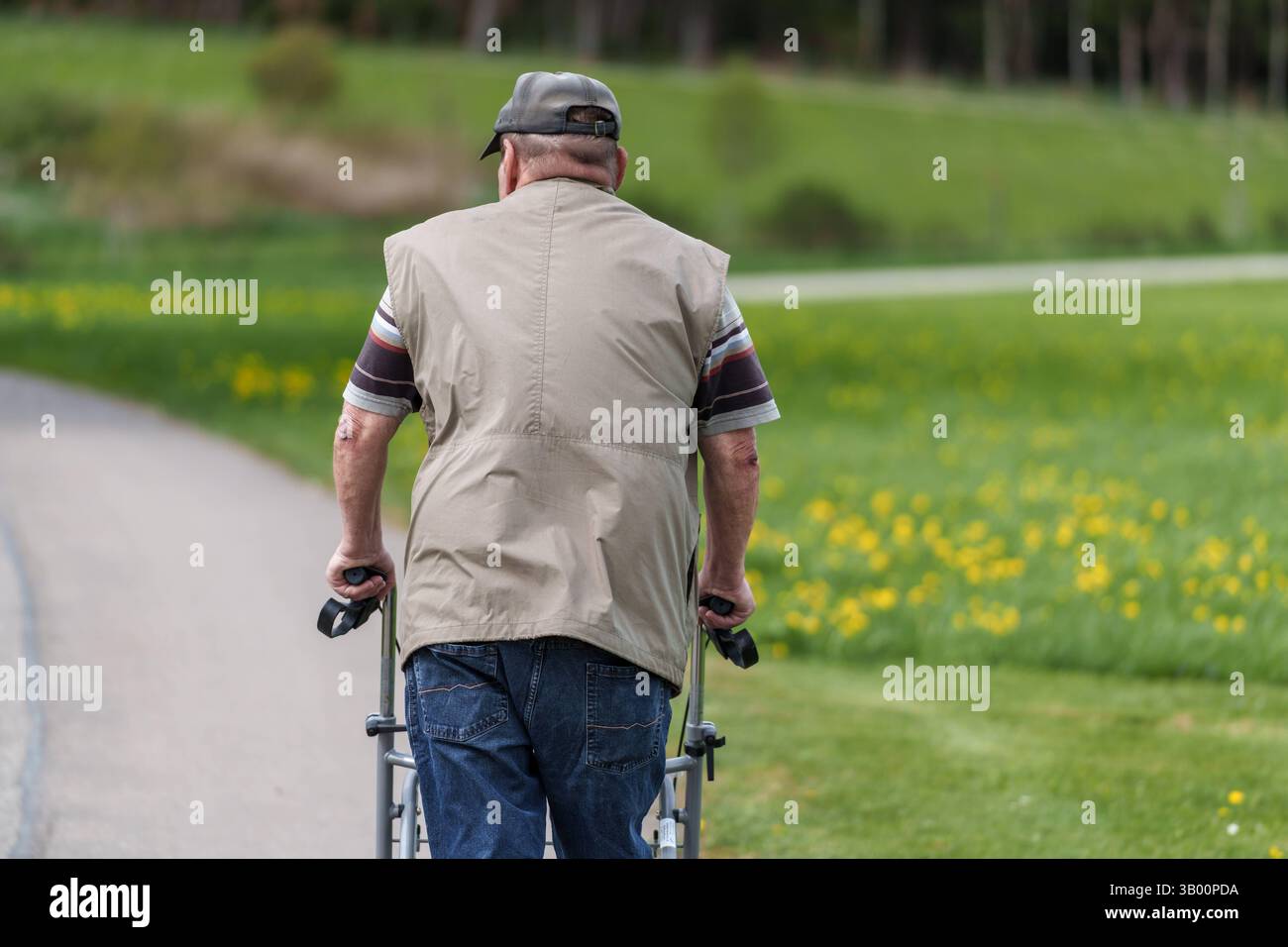 Bavaria, Germany - April 20, 2025: An elderly man walks with a walker ...