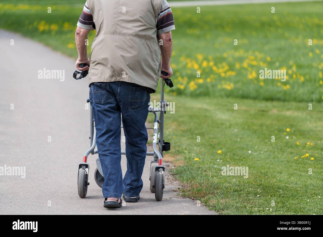Bavaria, Germany - April 20, 2025: An elderly man walks with a walker ...
