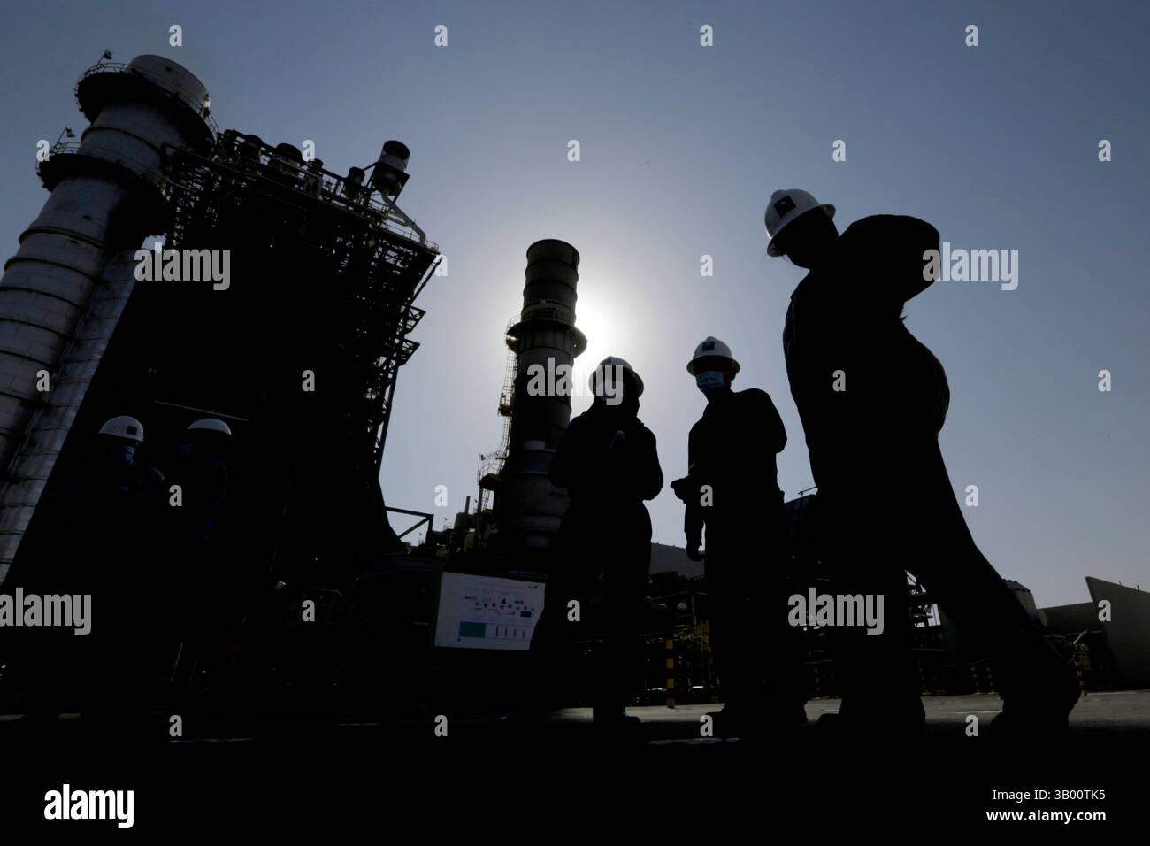 FILE - Saudi Aramco engineers walk in front of a gas turbine generator ...