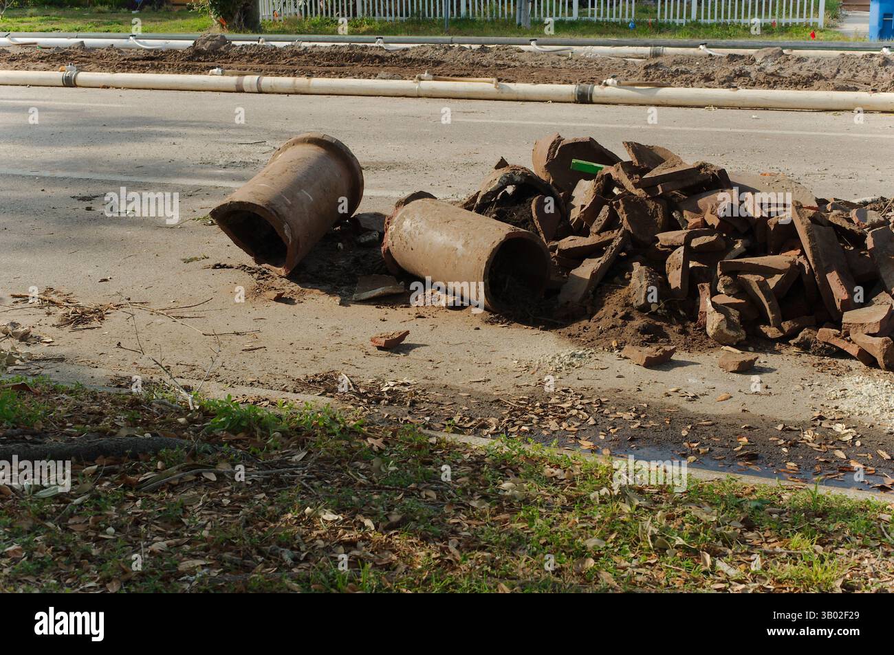 Construction Debris and Broken Pipes on Urban Road Surface. A pile of ...