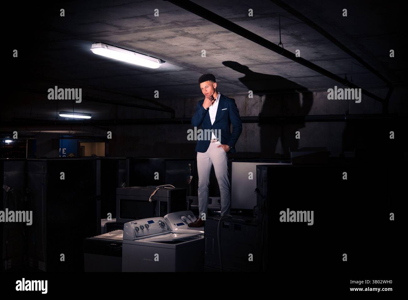 Man in formal wear leaning on concrete wall in dramatic hi-res stock ...