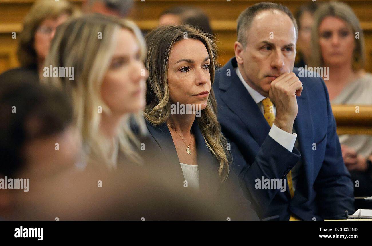 Karen Read, center, listens to testimony from witness Kerry Roberts ...