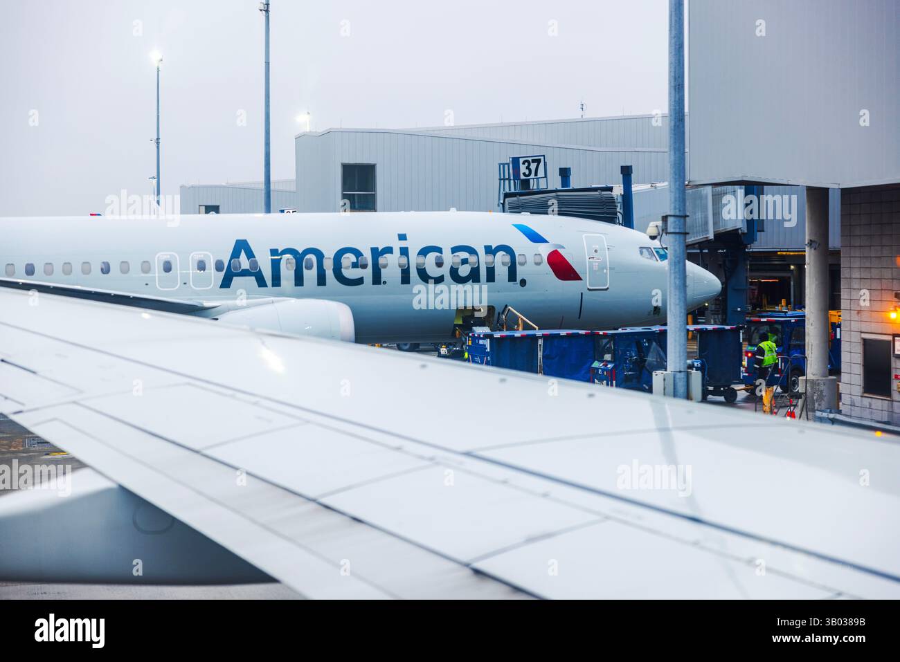 American Airlines airplane at boarding gate with crew and vehicles seen ...