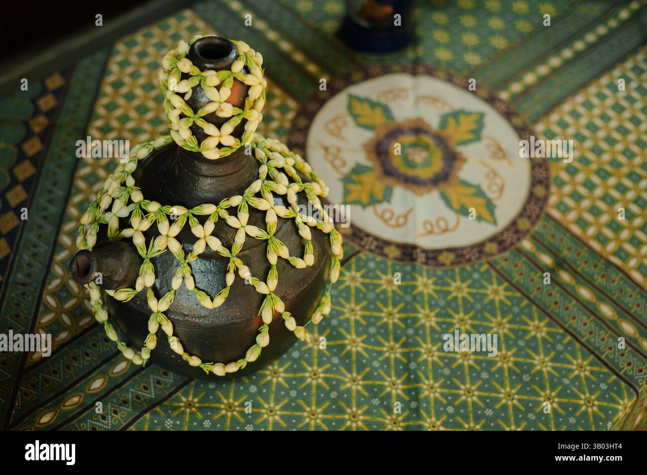 A traditional clay pot with green petals decoration. The pot is used ...