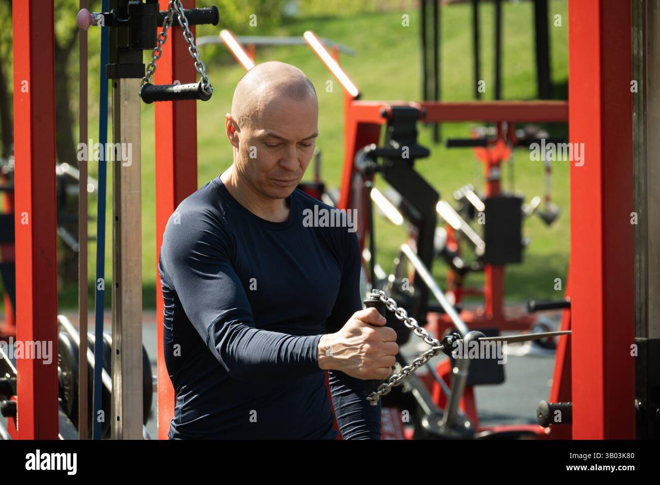 Adult caucasian man training exercising crossover trainer at public gym ...