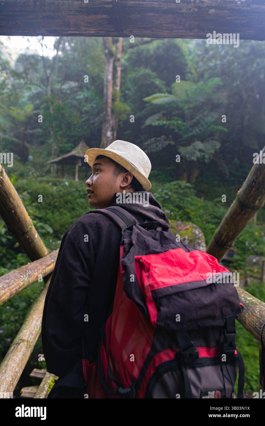 Asian man with straw hat and a backpack traveling and walking through a ...