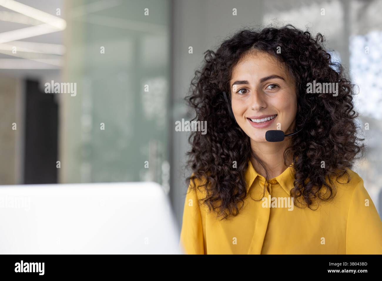 A smiling, customer service representative wearing a headset looks ...