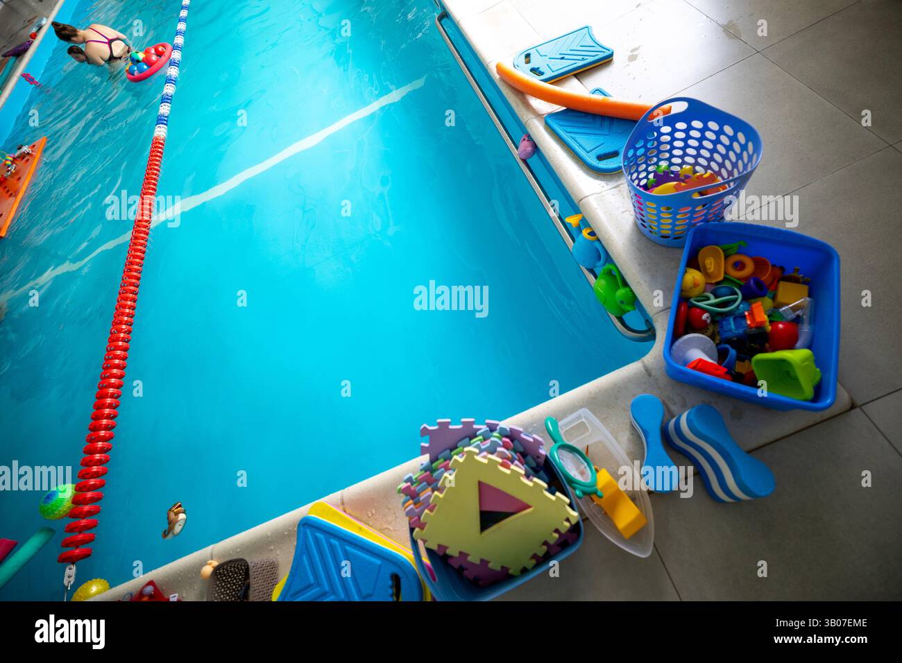 A brightly lit indoor children's swimming pool with clear, shallow ...